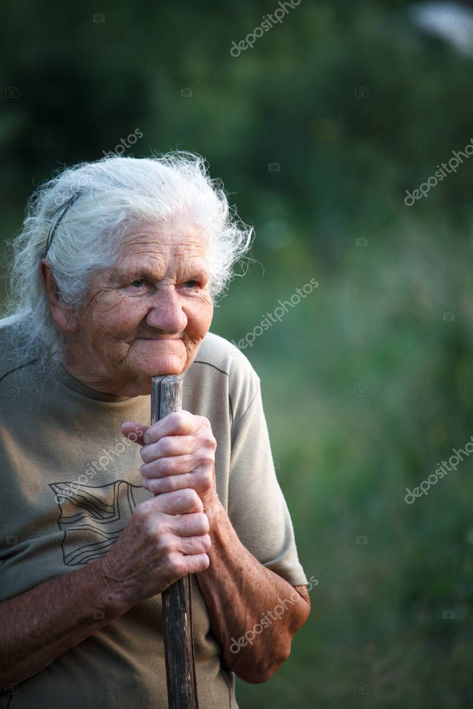 Un retrato de cerca de una anciana con el pelo gris sonriendo y mirando ...