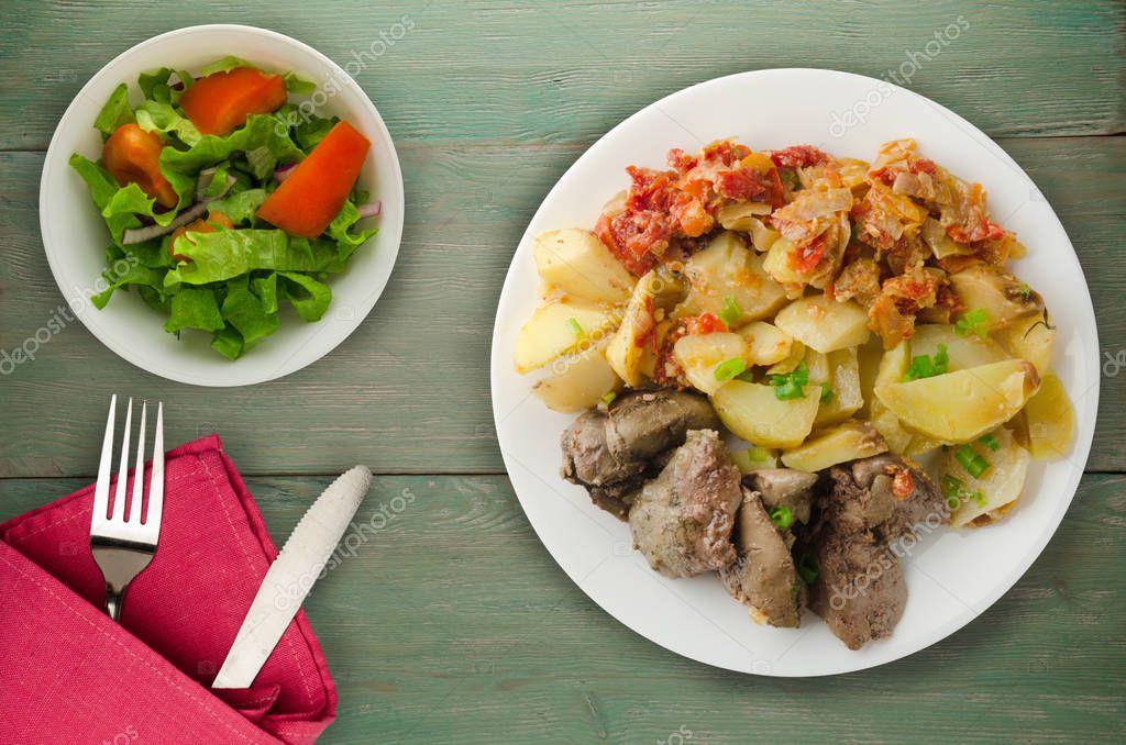 hígado frito con patatas y tomates guisados. hígado frito en el plato ...