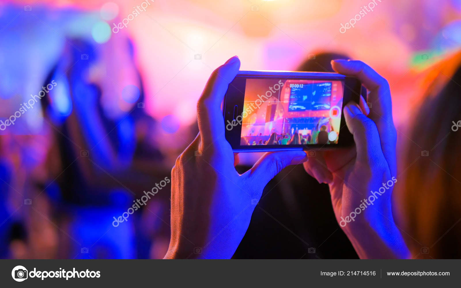 Hands silhouette recording video of live music concert with smartphone ...