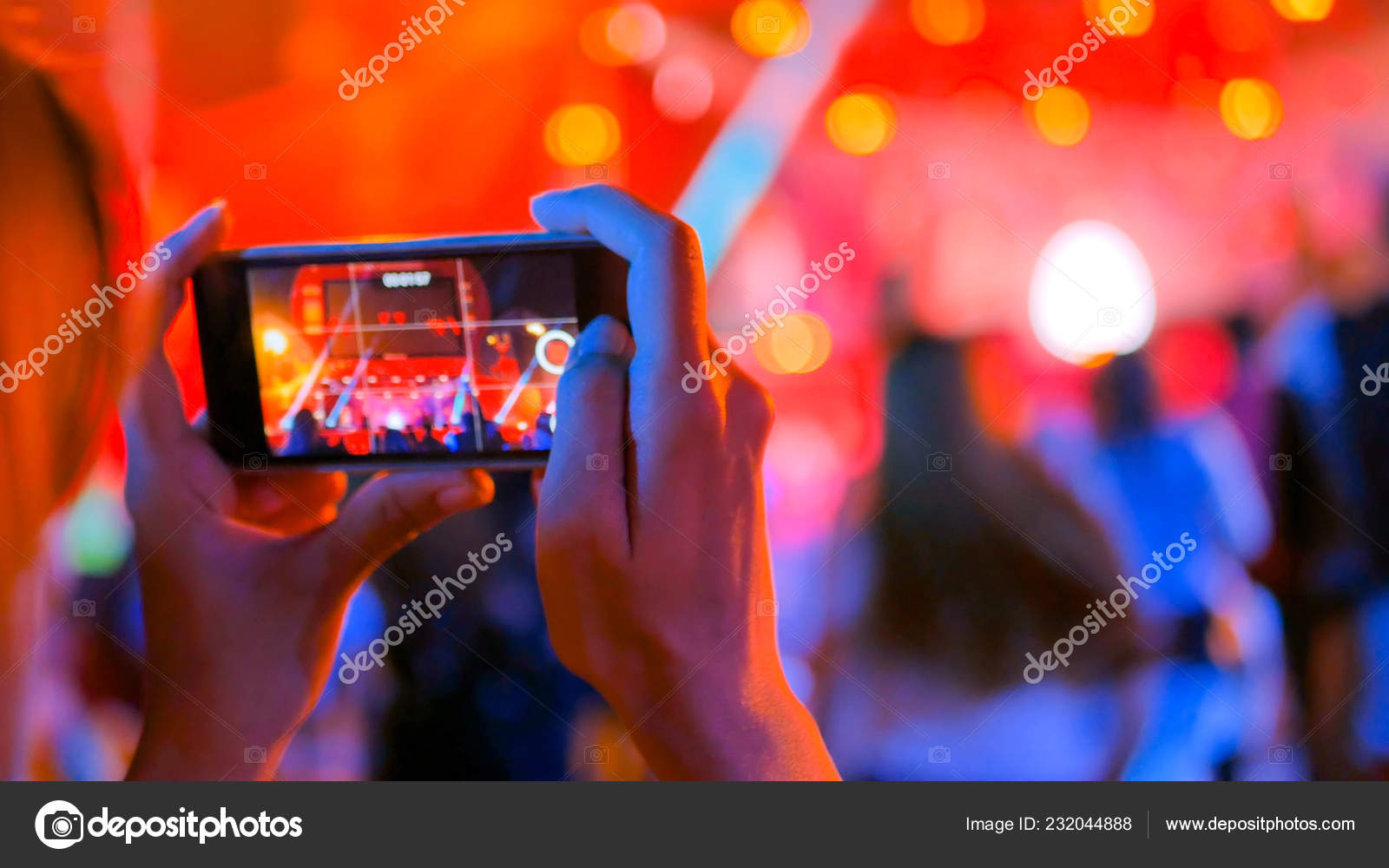 Hands silhouette recording video of live music concert with smartphone ...