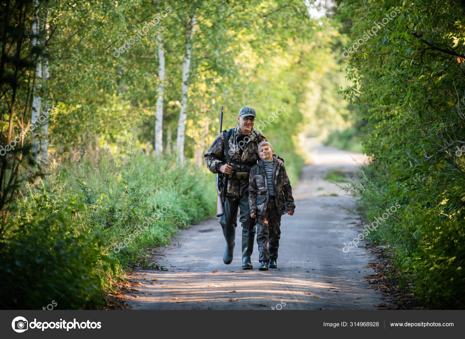 Father and son together hunting together. Walking the road in a forest ...