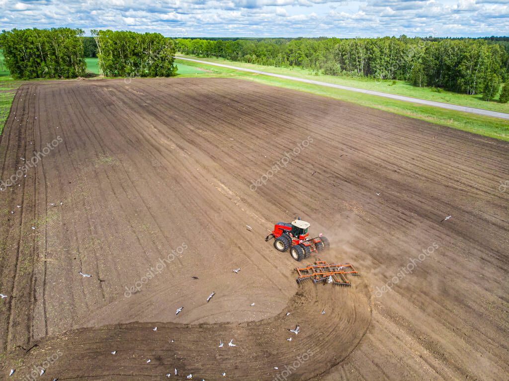 Tractor trabajando en los campos, vista aérea. Heno en el campo. La ...