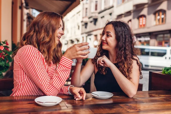 Happy female friends having coffee in outdoor cafe in summer on the ...