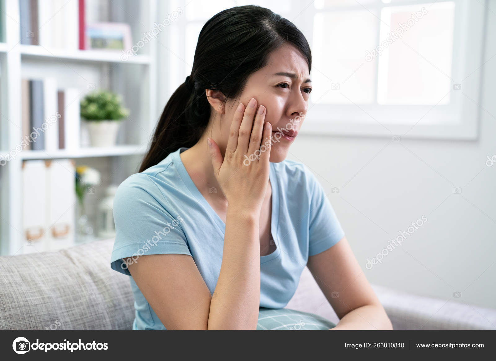 Asian woman has toothache sitting on couch Stock Photo by ...