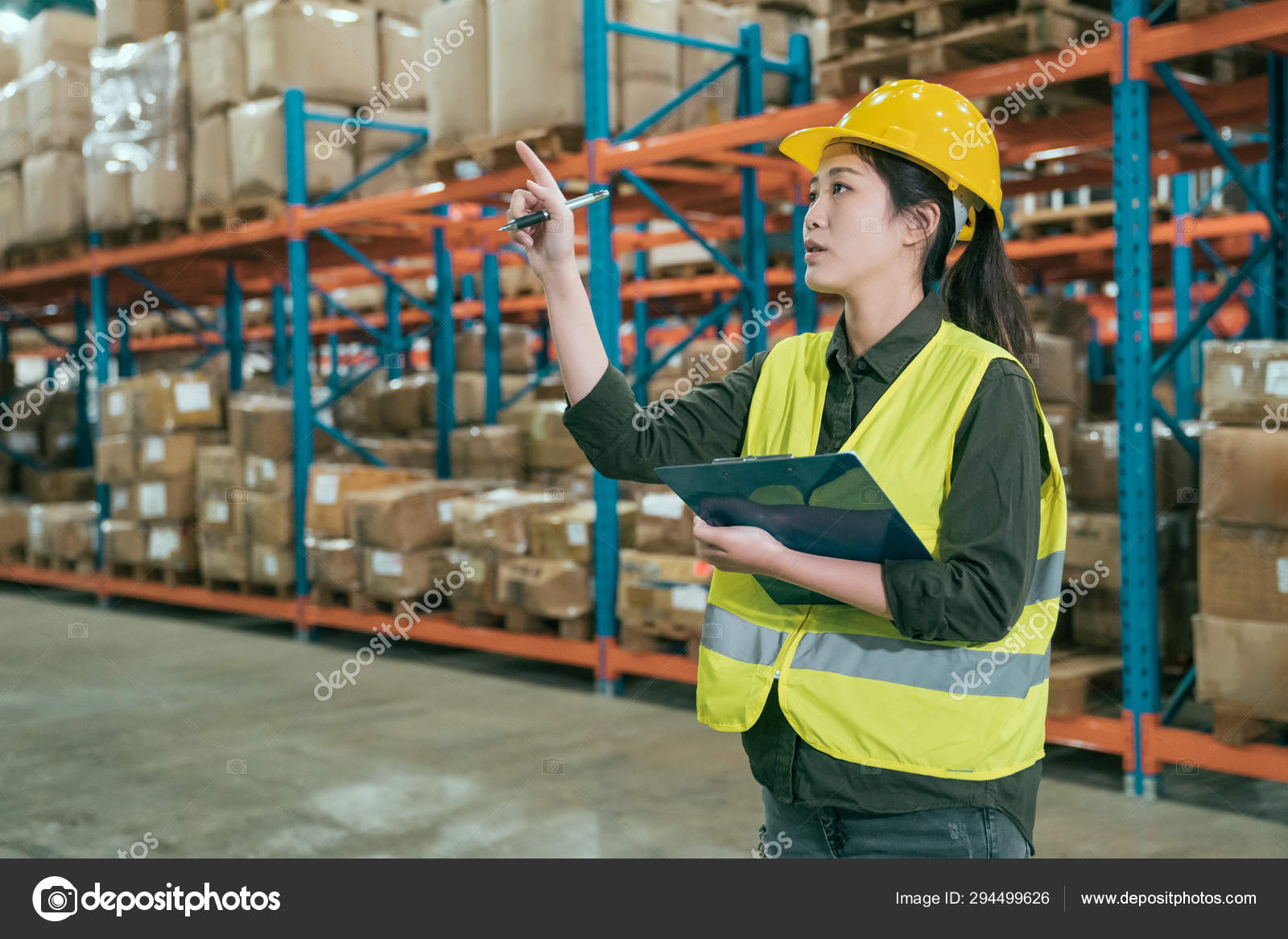 Woman in warehouse checking inventory of goods Stock Photo by ...