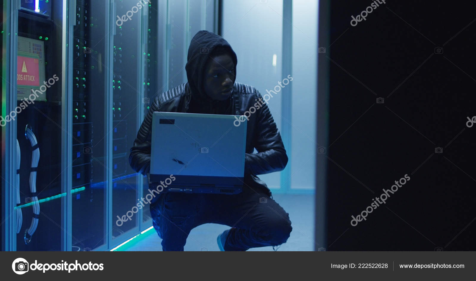 Crouched hacker in a data center Stock Photo by ©EvgeniyShkolenko 222522628