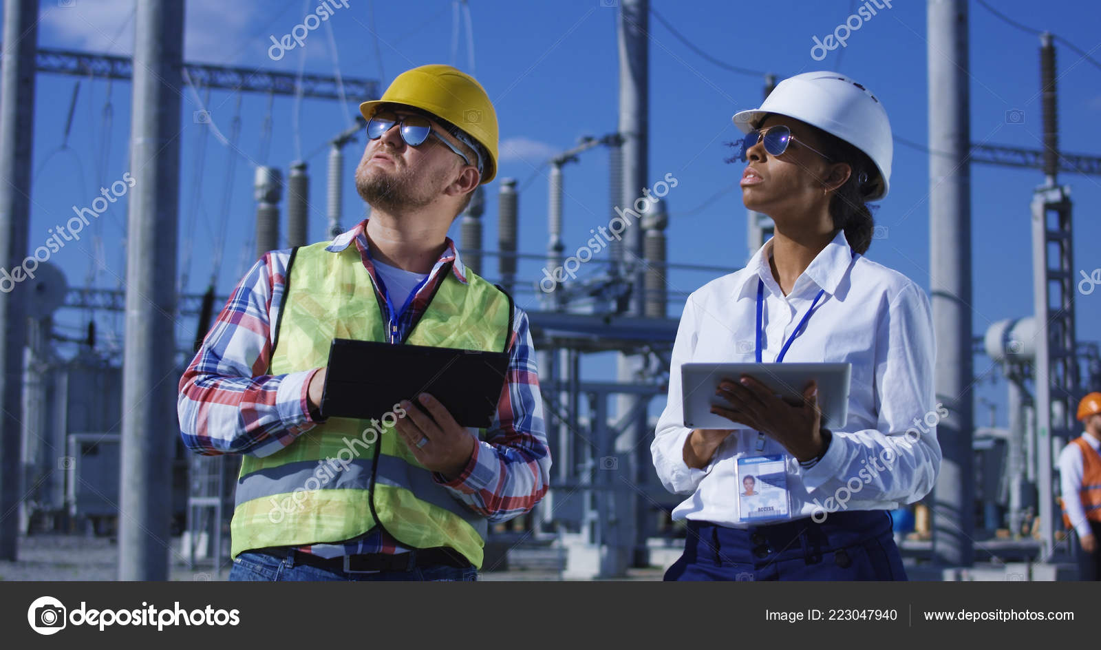 Two electrical workers on tablets outside Stock Photo by ...