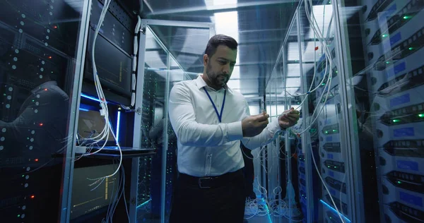Three people working in a data center with cable - Stock Image - Everypixel
