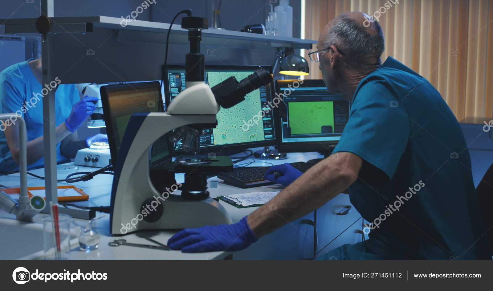 Biologist analyzing sample with microscope Stock Photo by ...
