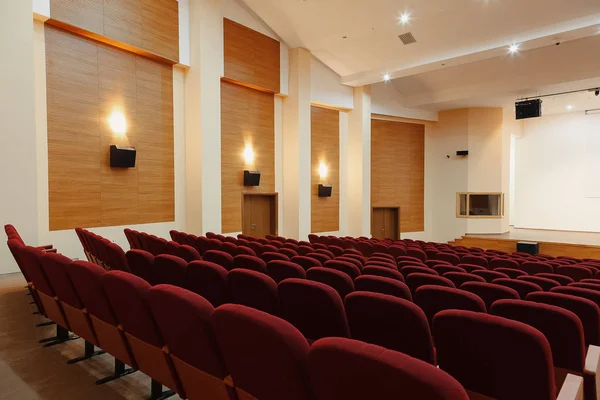 Large empty lecture hall with red chairs. - Stock Image - Everypixel