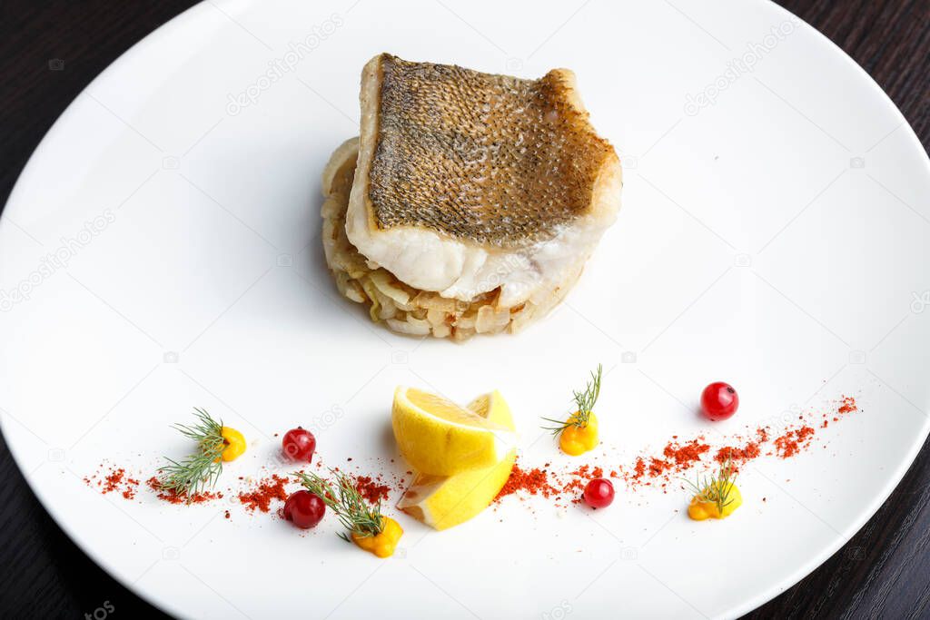 filete de pescado cocido de lucioperca sobre un lecho de cebolla ...