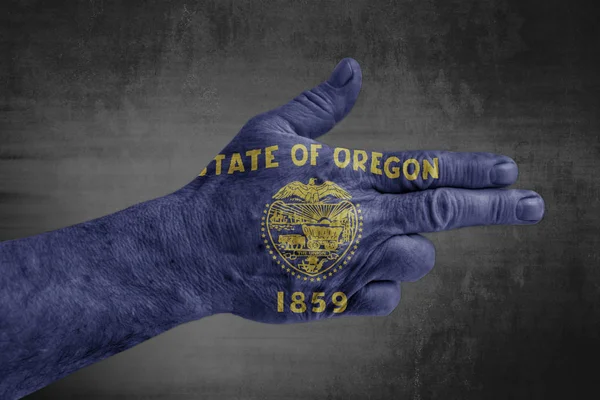 Oregon State flag painted on male hand like a gun - Stock Image ...