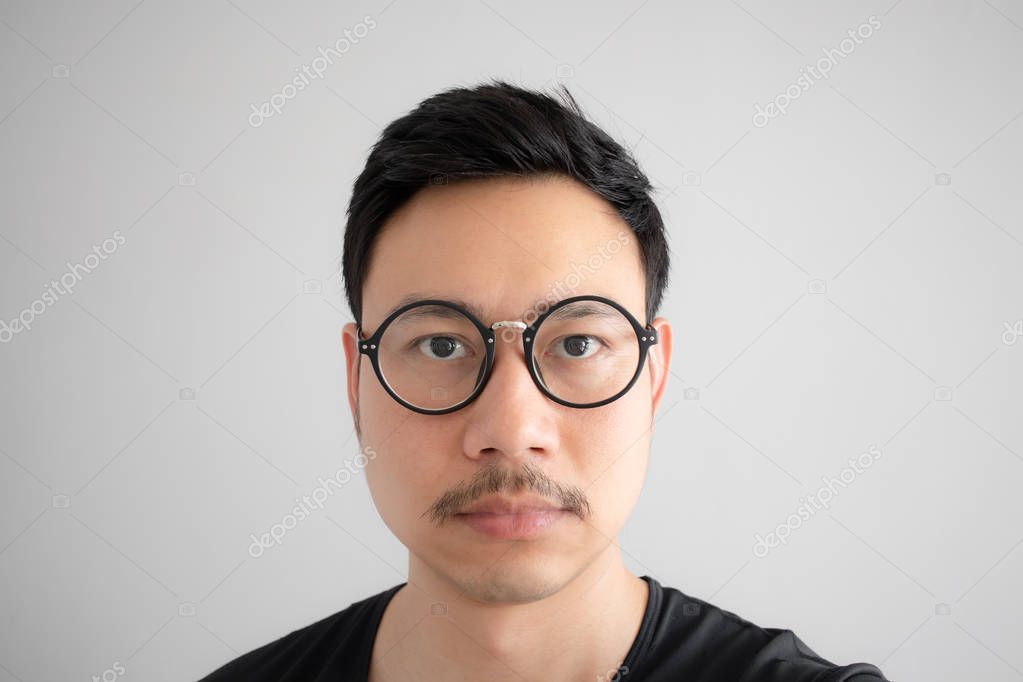 Cara normal de chico nerd asiático con gafas y bigote en camiseta negra ...