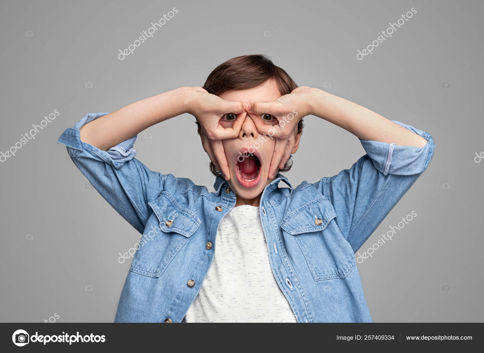 Amazed boy making hand mask gesture Stock Photo by ©kegfire 257409334