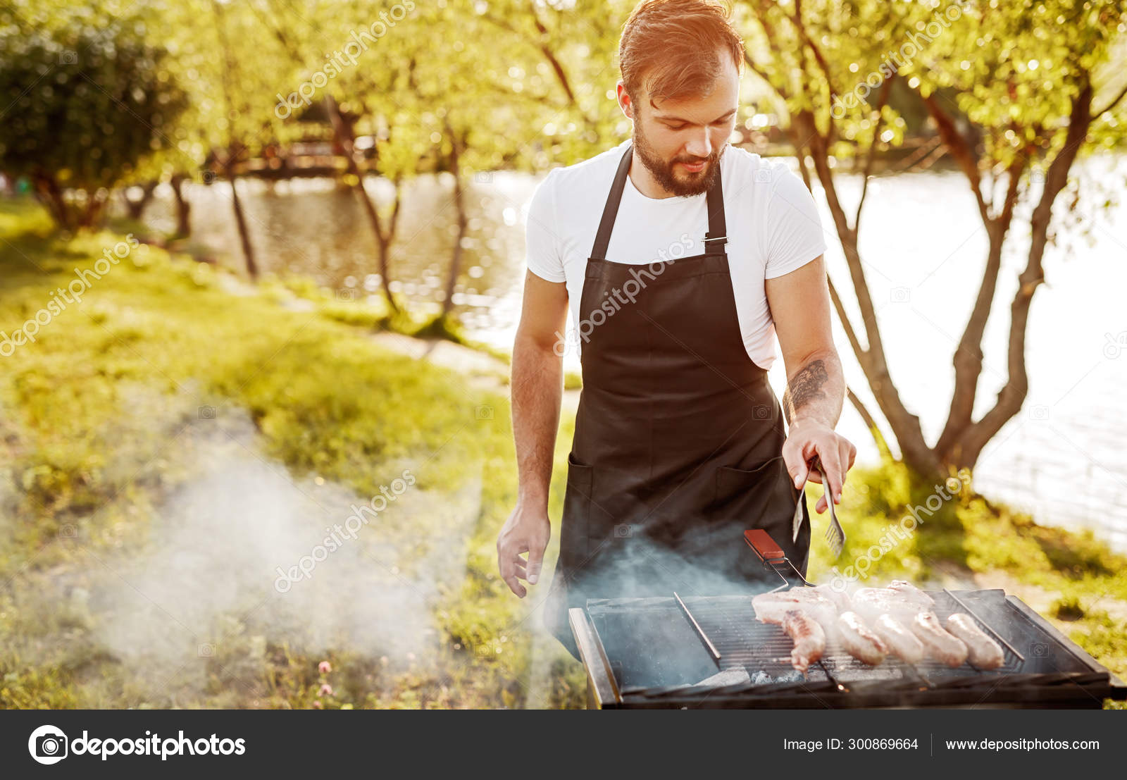 Chef smoking sausages on grill Stock Photo by ©kegfire 300869664