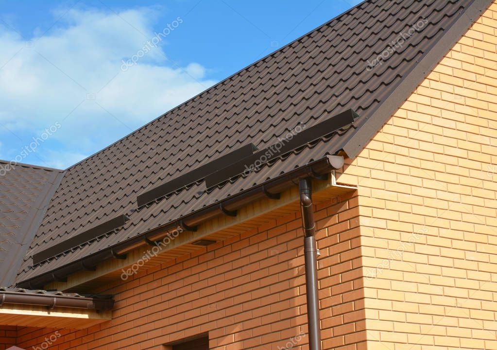 Techo de casa de ladrillo con techo de metal, tubería de canalón de ...