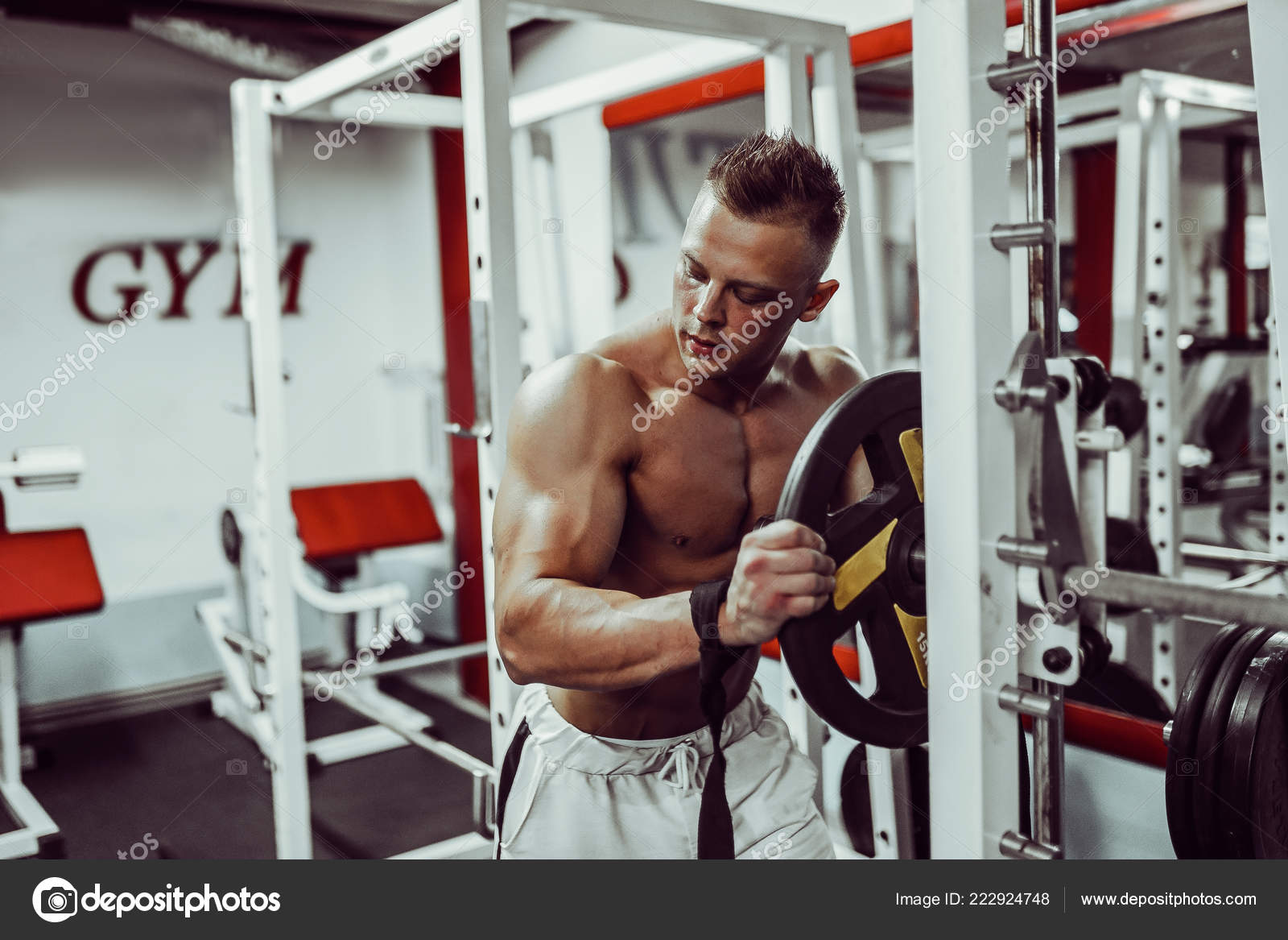 Bodybuilder preparing for exercise with barbell in gym Stock Photo by ...