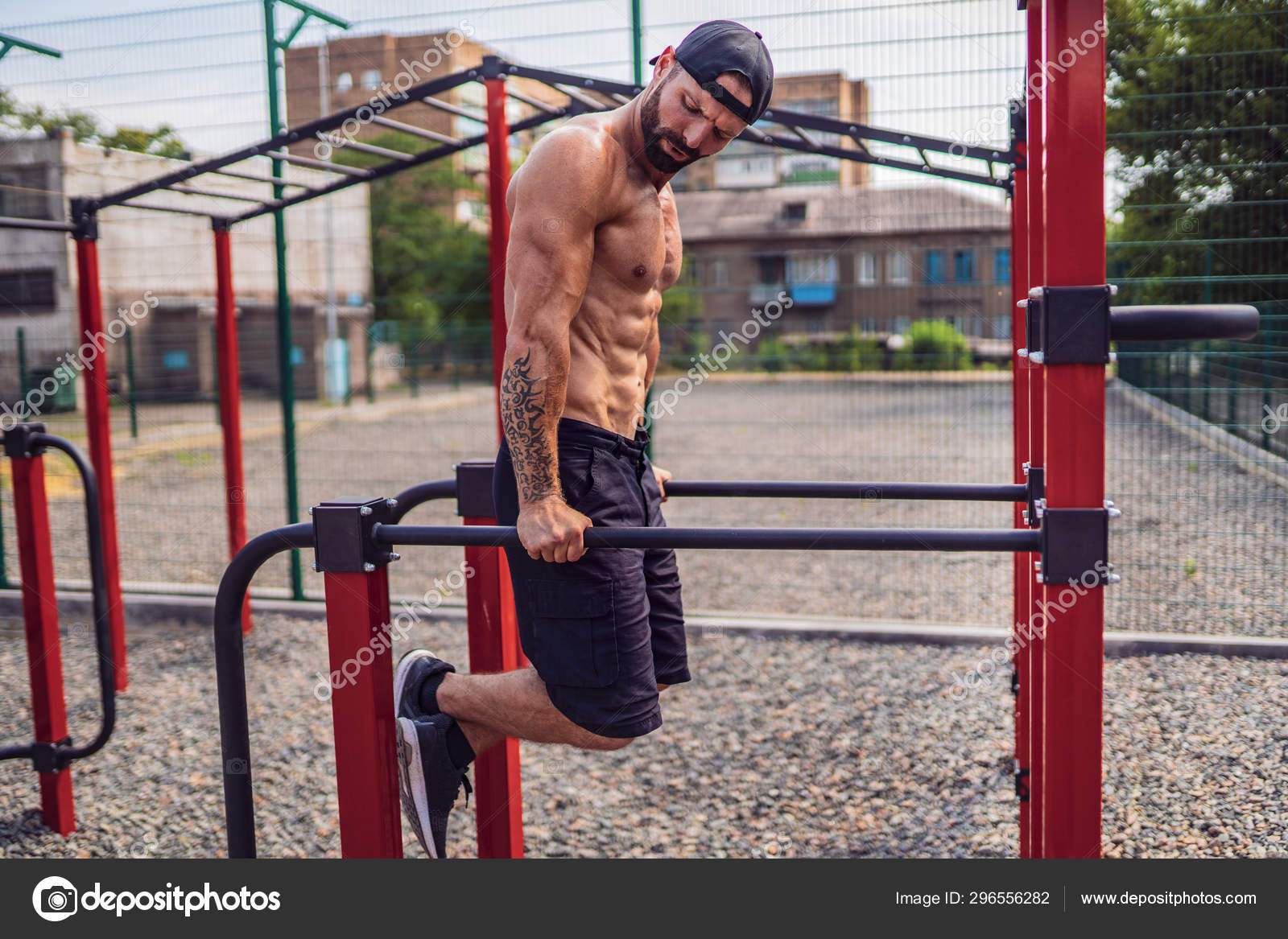 Starker muskulöser Mann macht Liegestütze auf unebenem Stufenbarren in ...