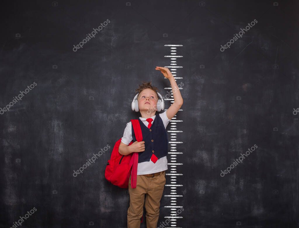 Un niño midiéndose a sí mismo. Niño de la escuela midiendo su ...