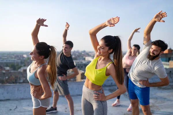 Group of happy sporty people training outdoors on rooftop - Stock Image ...