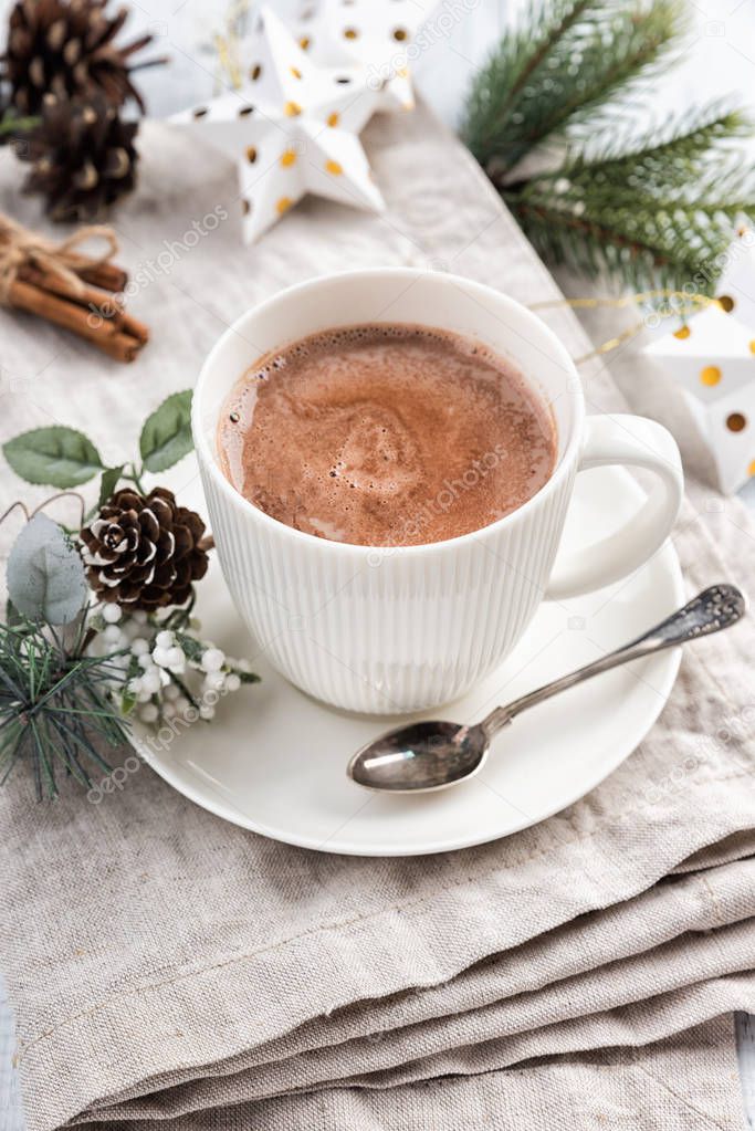 Copa de chocolate caliente con palitos de canela en la mesa de madera ...