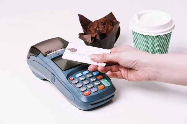 Woman pay by card. NFC payment terminal and take away cup of coffee ...
