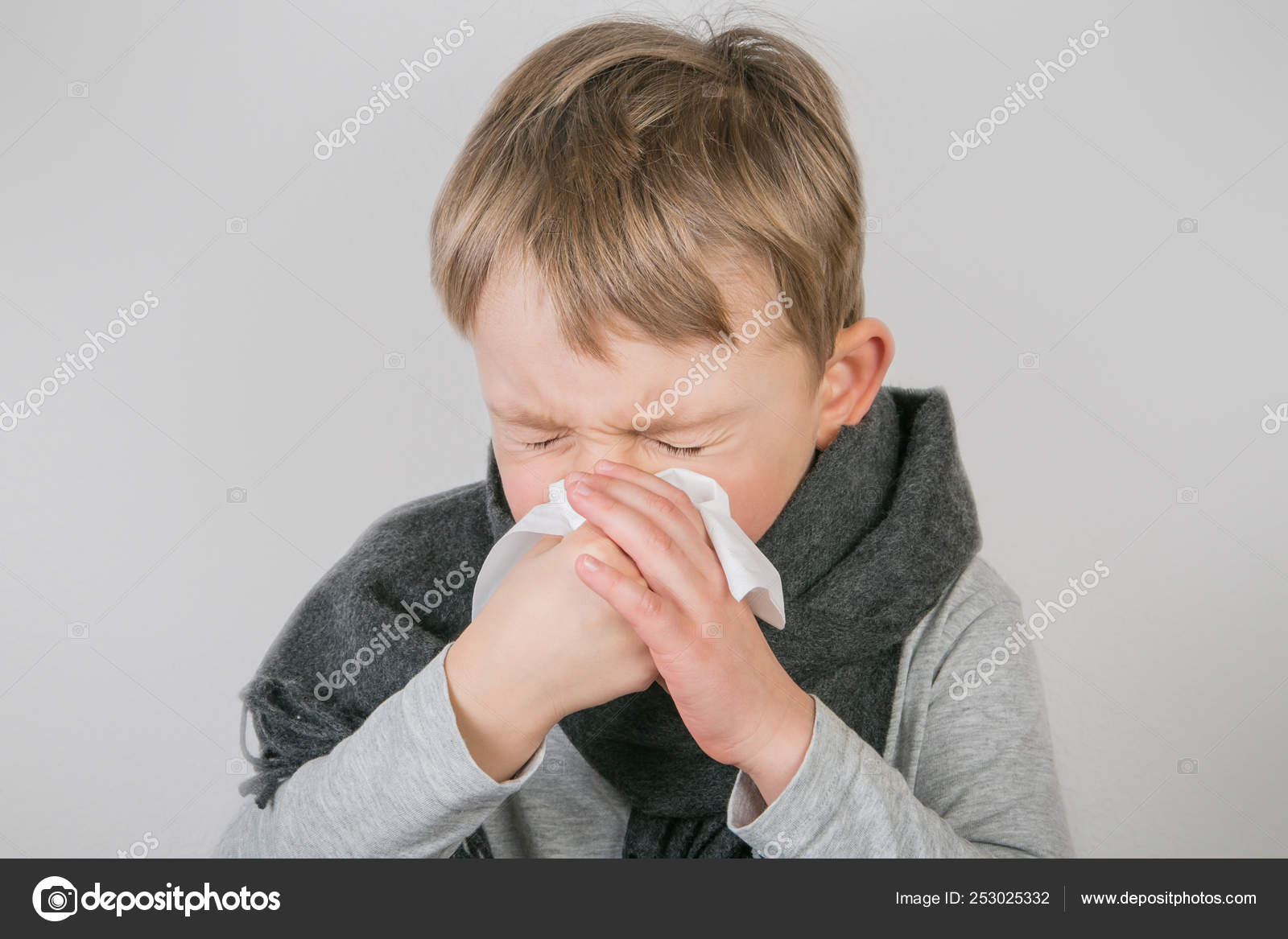 Sick boy sneezes, grey background Stock Photo by ©anaumenko 253025332