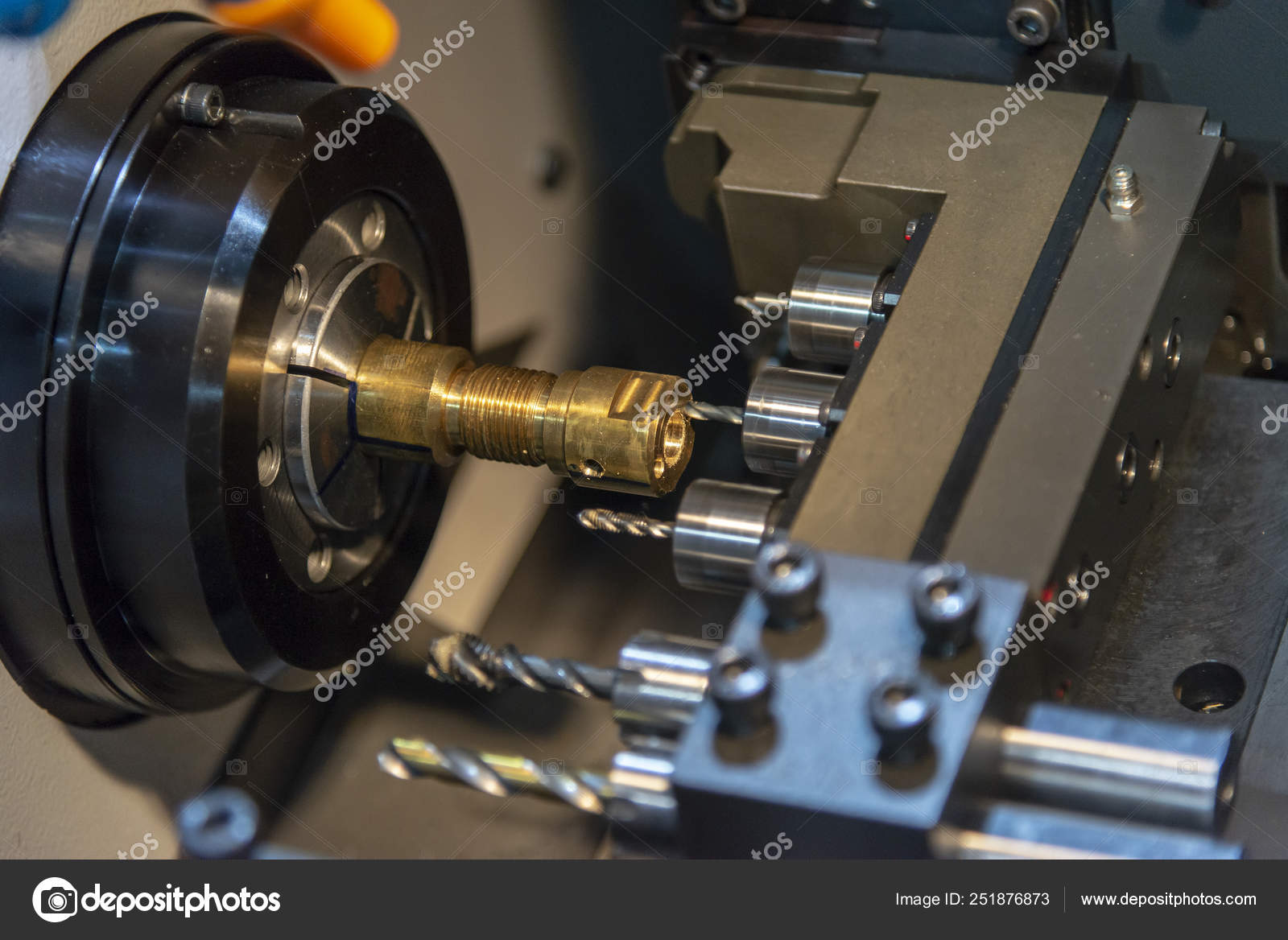 A máquina de torno CNC perfurando o furo na parte do eixo de latão ...