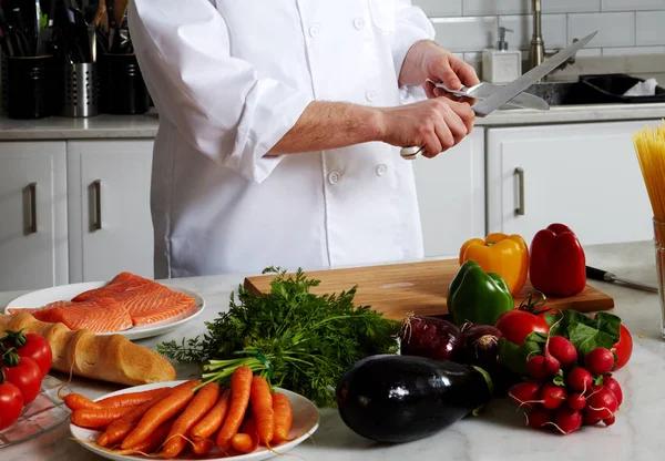Chef sharpens a knife on a modern stylish kitchen expensive Italian ...