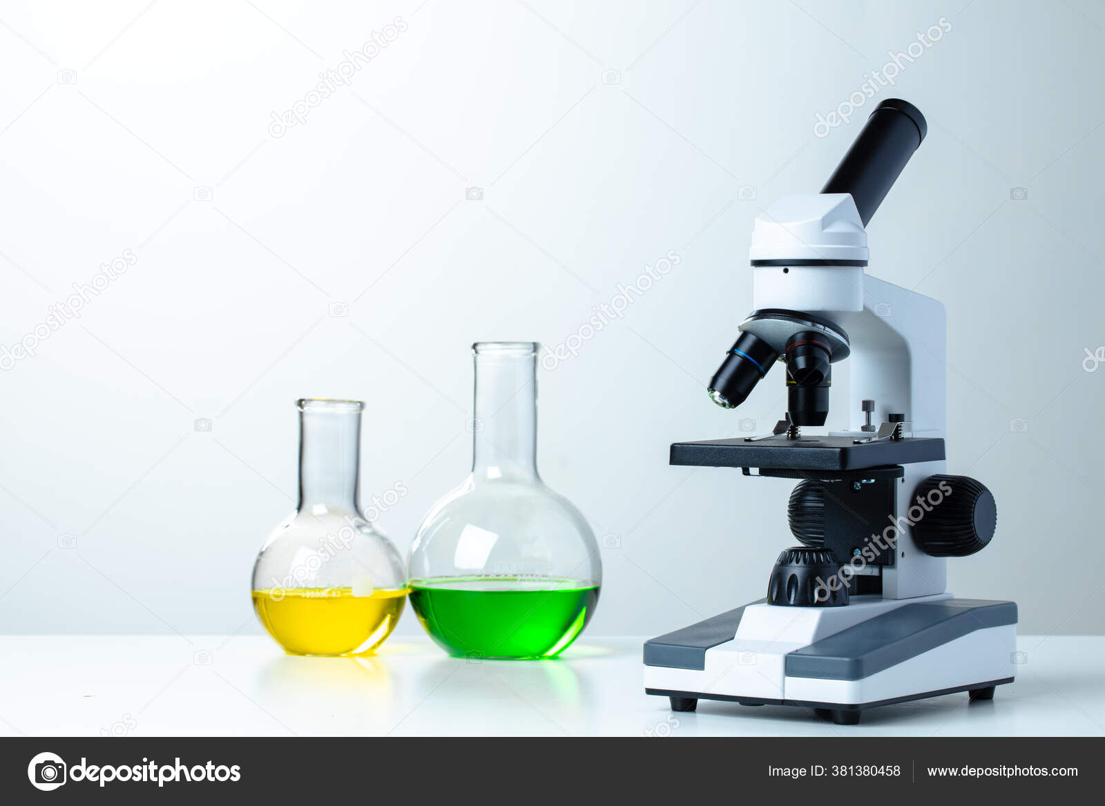 Lab microscope with laboratory glassware on desk Stock Photo by ...