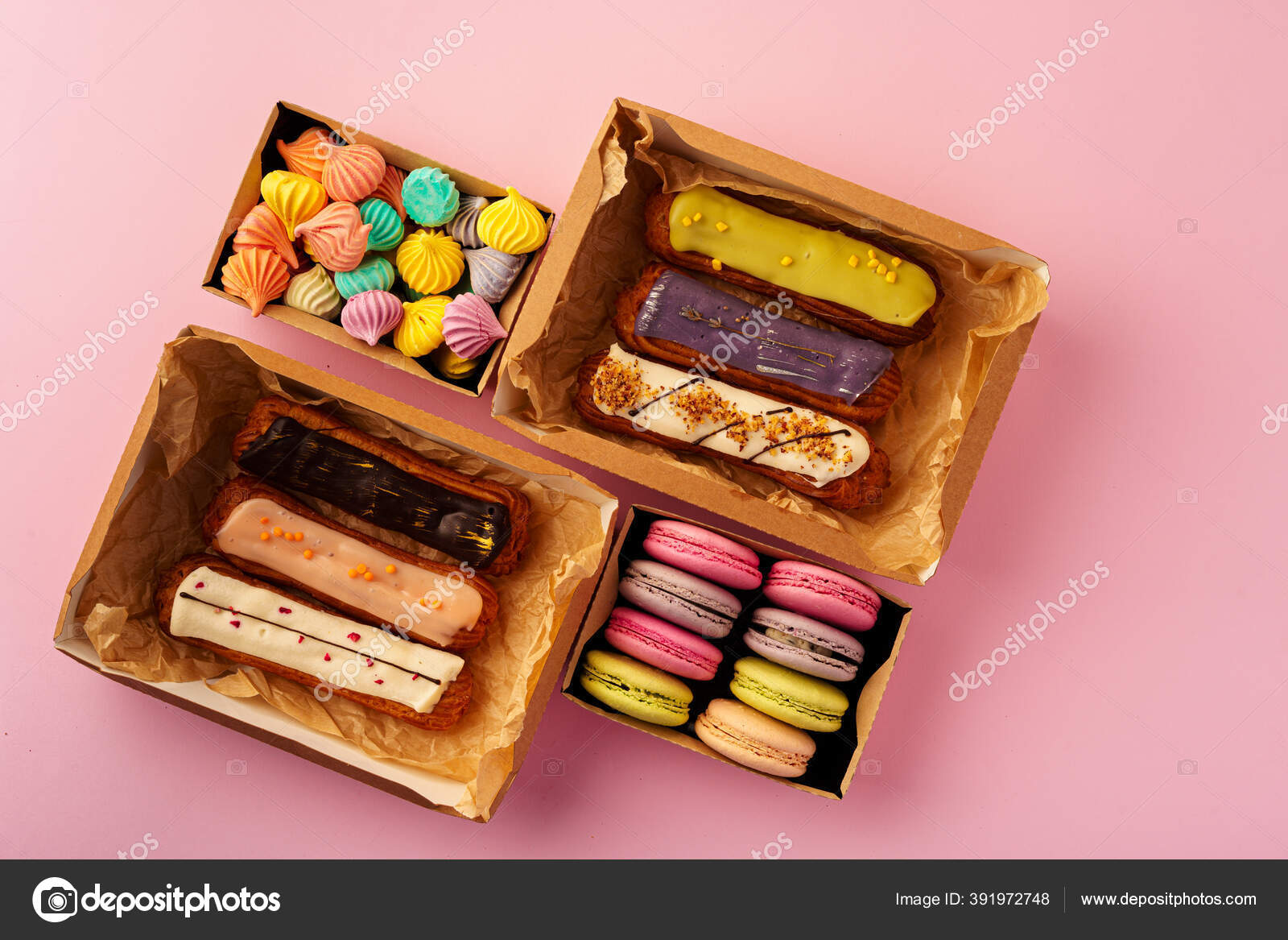 Carton boxes with eclair cakes and cookies on pink surface Stock Photo ...