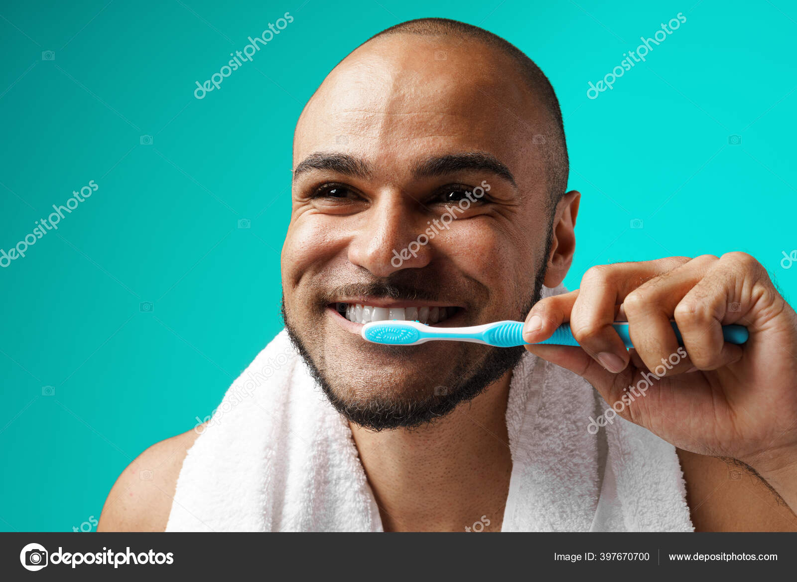 Cheerful dark-skinned male brushing his teeth against turquoise ...