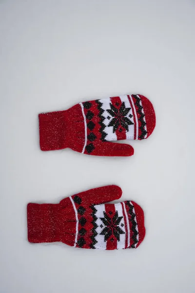 two red knitted mittens with black snowflake pattern isolated on white ...
