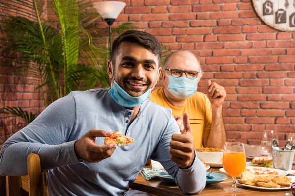 Indian family wears face mask while eating food in restaurant after ...