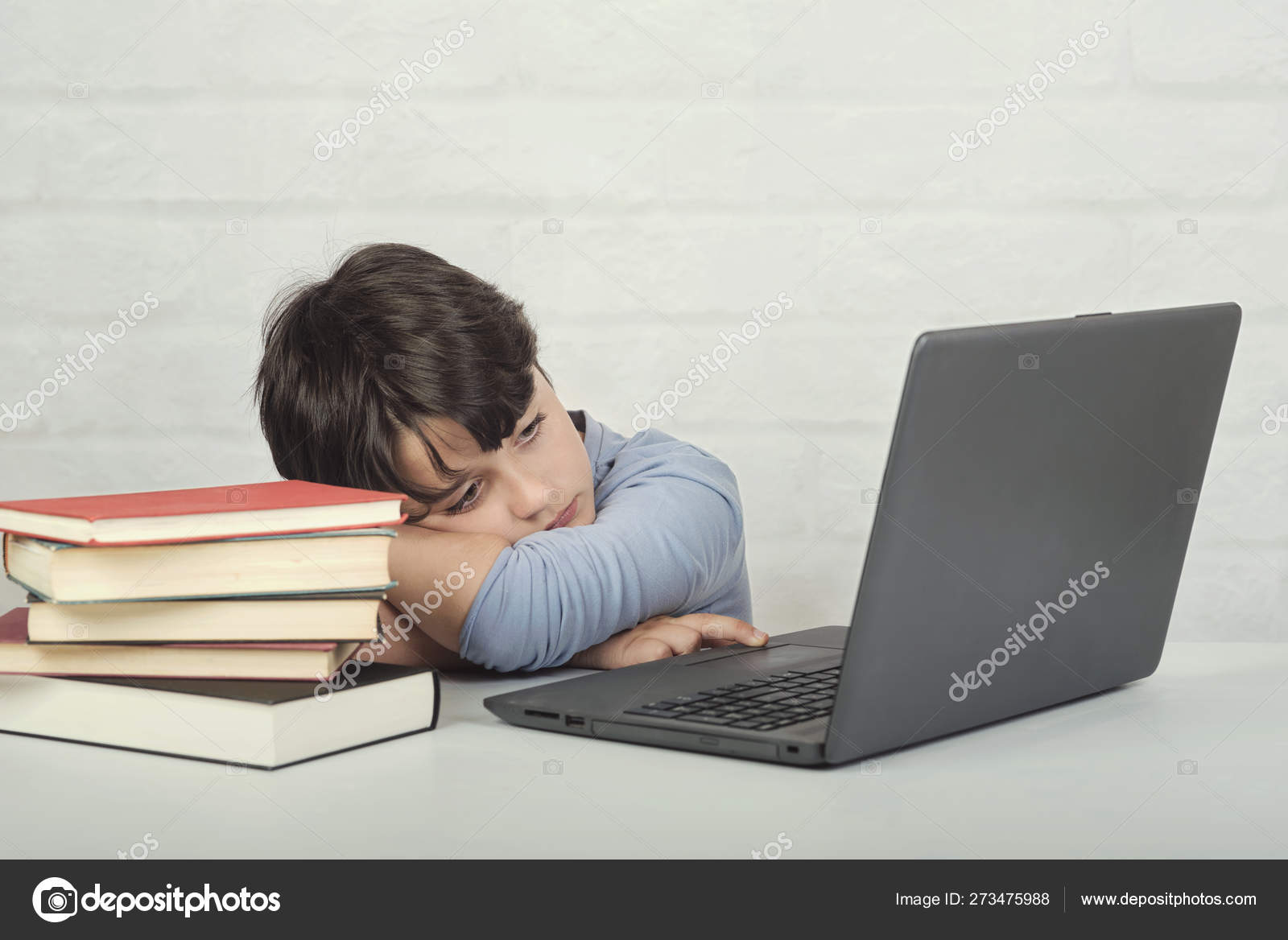 Sad boy with laptop computer and books Stock Photo by ©esthermm 273475988