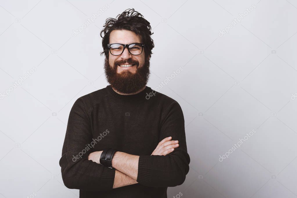 Feliz joven guapo inteligente con gafas y sonriendo a la cámara ...