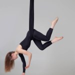 Beautiful girl in a black sport suit is performing an acrobatic ...