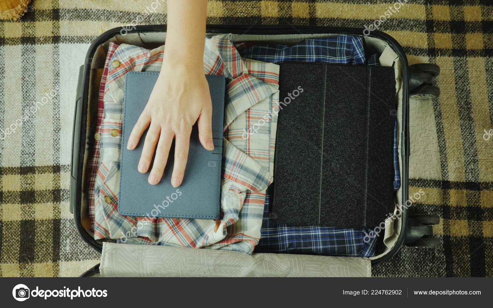 Woman puts a notebook in a travel suitcase — Stock Photo © StockSeller ...