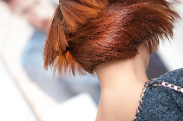 Accurate geometric shape short haircut on a woman with red hair in ...