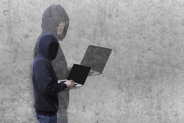 two-faced hacker hood and shadow with a face on a concrete background ...