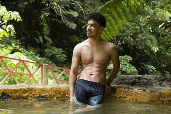 Portrait of Hispanic man floating in a natural pool with eyes closed ...