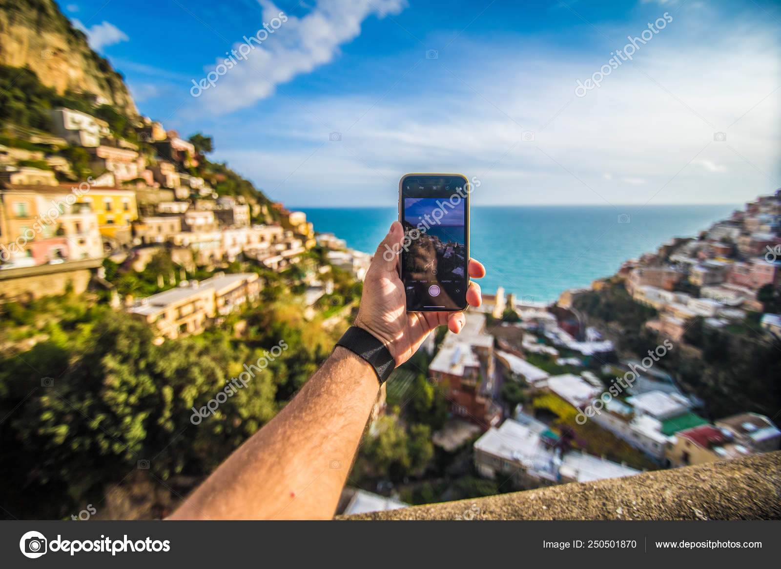 Man hand take photo on phone in front of Positano shore view — Stock ...