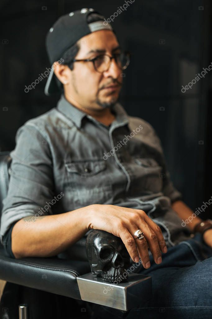 Hombre de estilo retro sentarse en la silla y sostener el cr neo con ...