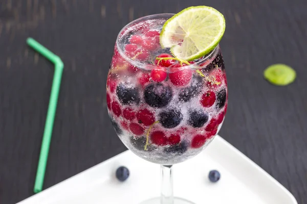 Glass with a cooling drink of berries and ice. Misted glass. Air ...