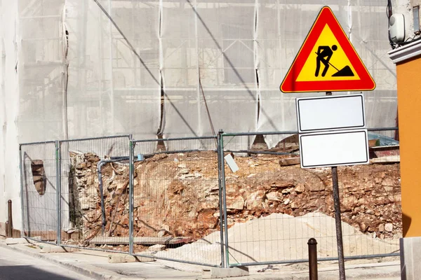 Road construction work and sign at a construction site. Warning sign ...