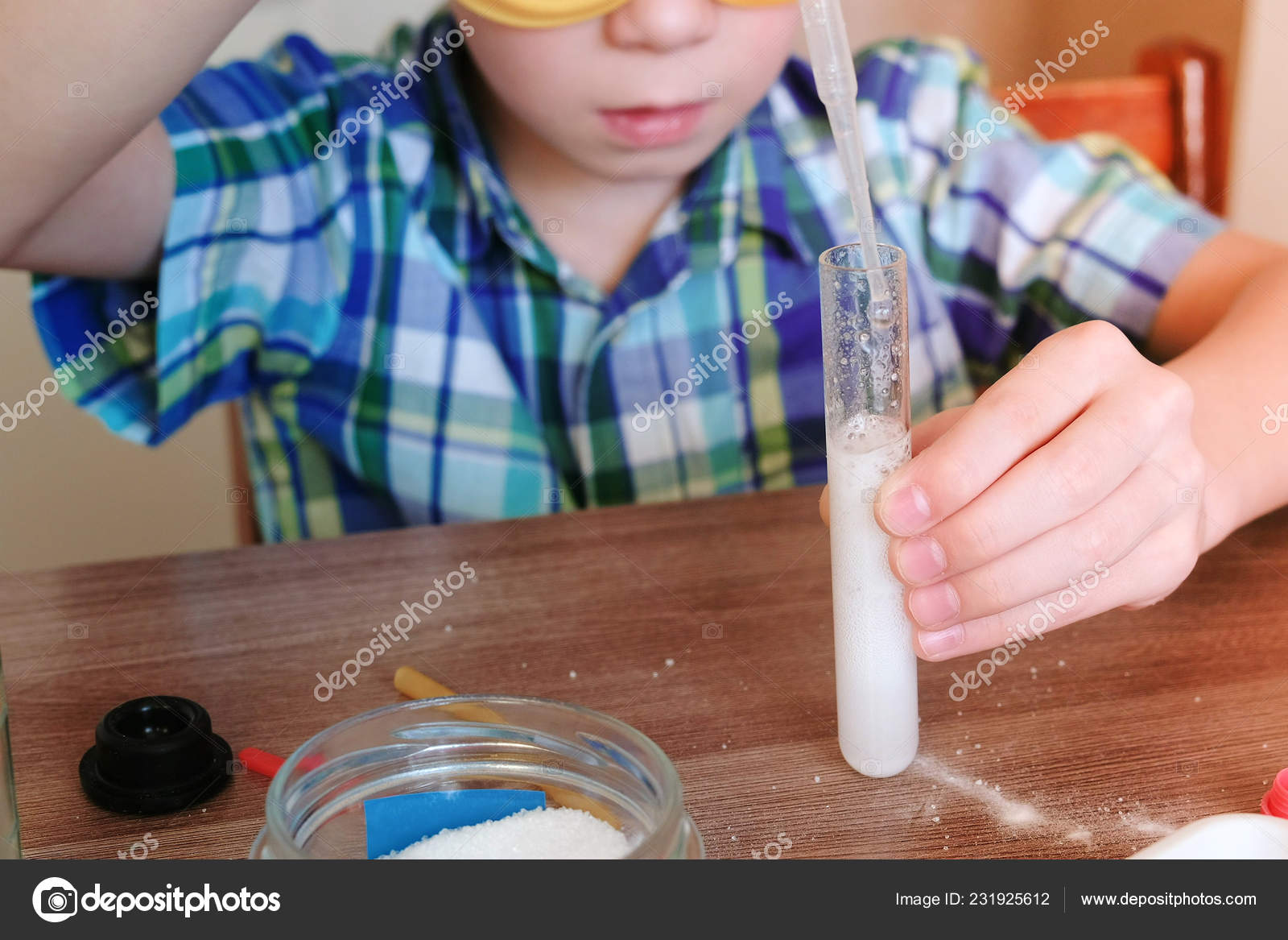 Experiments on chemistry at home. Boy Pour the water to test tube using ...