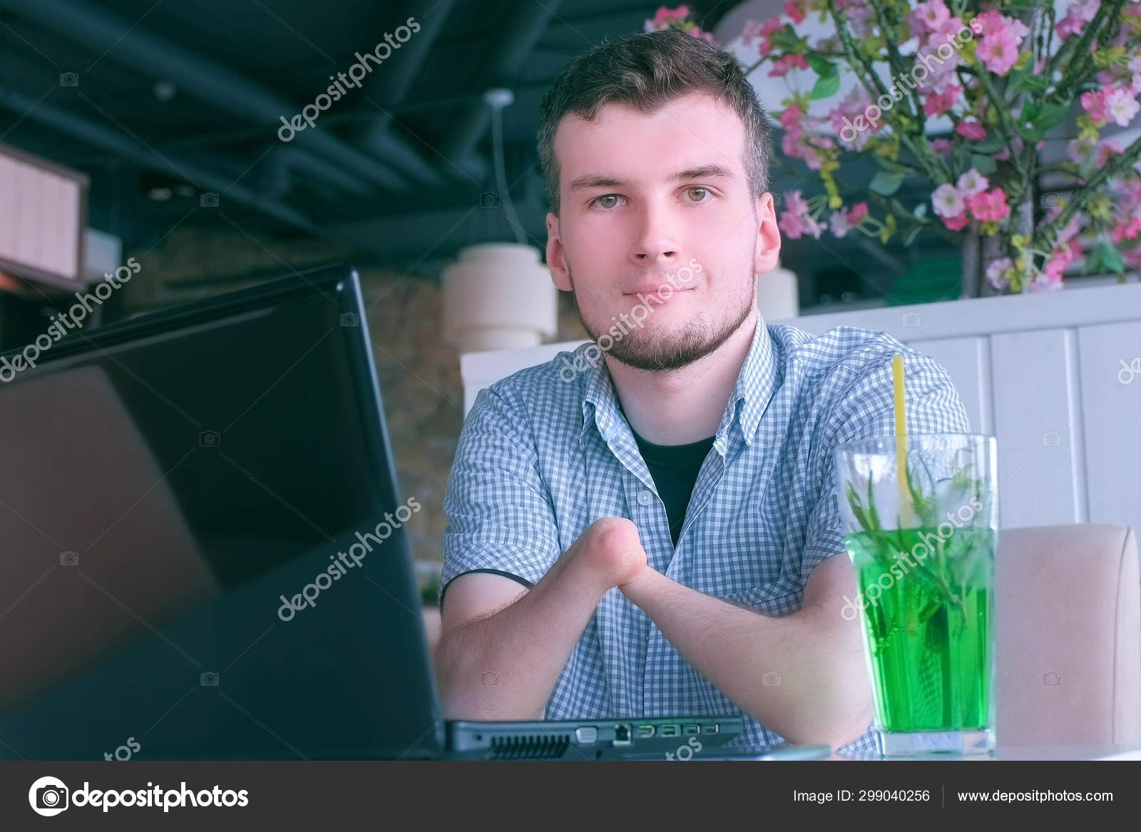 Optimistic disabled man with amputated two stump hands in cafe looks at ...