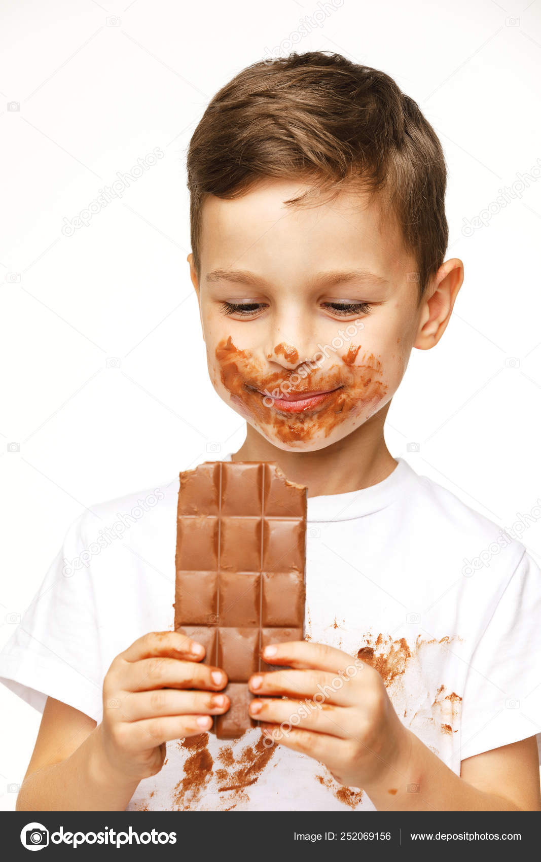 Little messy boy is eating chocolate studio shot — Stock Photo ...
