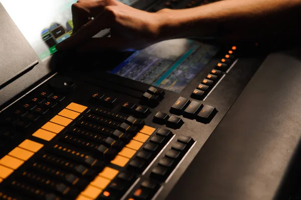 A lighting engineer works with lights technicians control on the ...