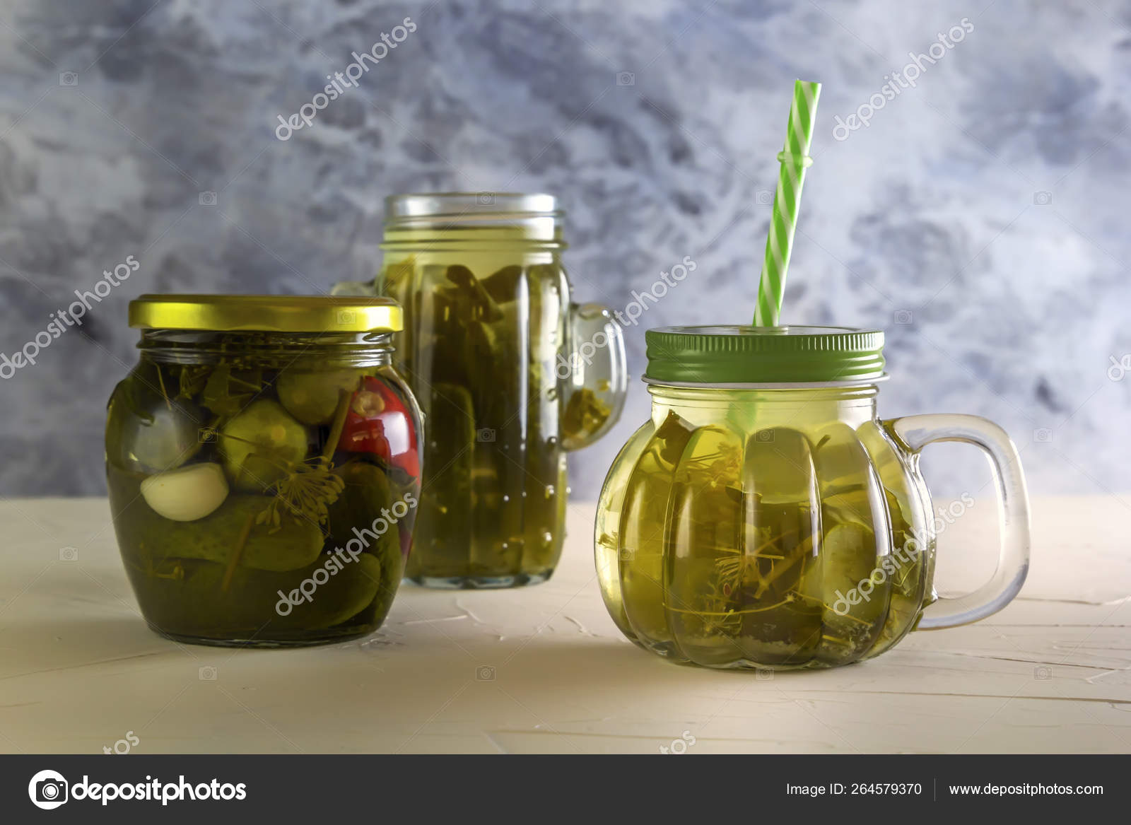 Cucumber pickle in a jar with a lid and tube on wooden table. Close-up ...